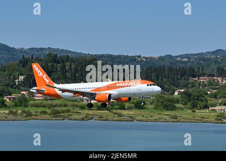An Easyjet Airbus aircraft descending over trees on final approach ...