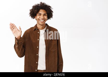 Friendly guy smiles and waves at you, says hello, hi gesture Stock ...