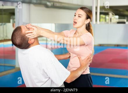 Woman performing eye-gouging move during self-defence training Stock ...
