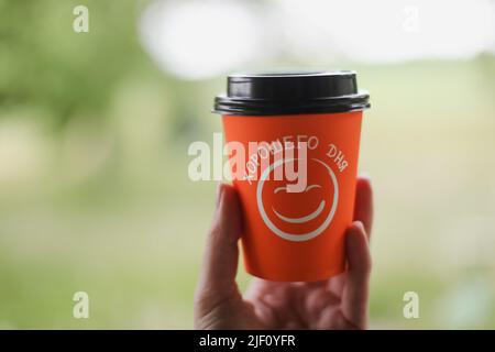 Good morning. Positive cup with smile on sunny green background of ...