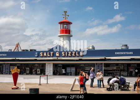 Salt & Sizzle and people on the boardwalk in Coney Island, Brooklyn ...