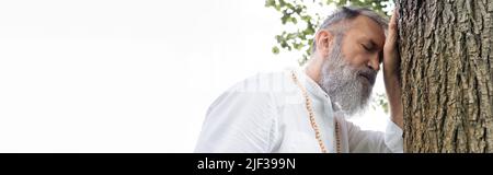 low angle view of bearded guru man meditating with closed eyes and ...