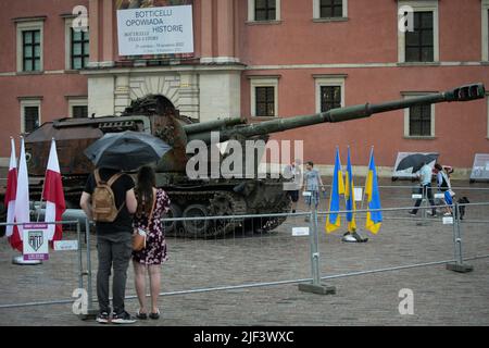 Visitors look at Russian tanks on display near the Royal Castle in ...
