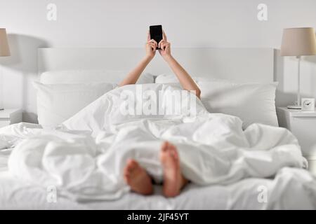 Anonymous woman with smartphone in hands and coffee cup near her Stock ...