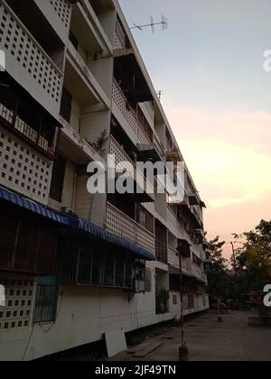 Old concrete residential building behind deciduous treetop, selective ...