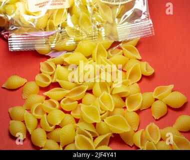 Shell-shaped pasta spills out of the package. Italian food. Cooking ...