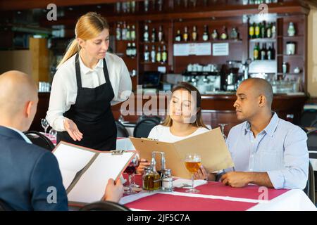 Polite waitress taking order from couple in pizza restaurant Stock ...