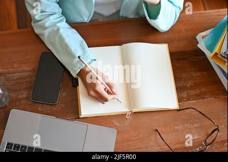 Overhead shot of college student doing an assignment, writing the ...