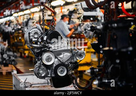 Powerful car motor hangs on chains in assembling workshop Stock Photo ...