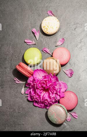 Macarons with peony flower on a stone background. Sweet dessert ...