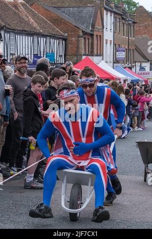 Two men of Pinner Players Theatre Company push a wheel barrow down ...