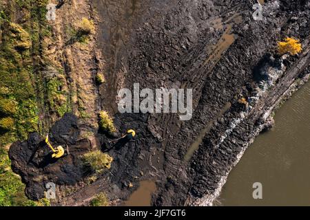 Crawler excavator cleans the pond of silt and algae. Earthworks service ...