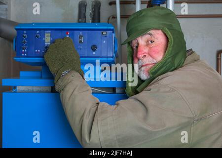 Poverty concept. Man with red gloves holding a metal bowl of soup ...