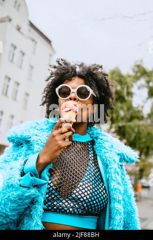 Fashionable young woman eating dessert Stock Photo - Alamy