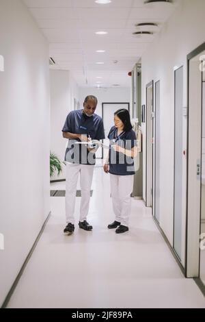 Mature nurse with colleague discussing over computer at hospital Stock ...
