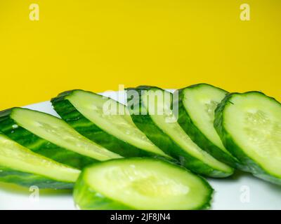 A smooth, medium-sized cucumber on white plate, sliced. Cucumber on a ...