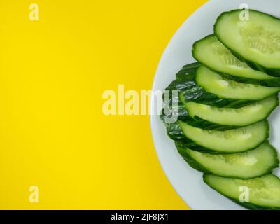 A smooth, medium-sized cucumber on a plate, sliced. Cucumber on a ...