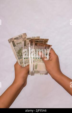 Hand holding Indian New 100 rupee notes on isolated background Stock ...
