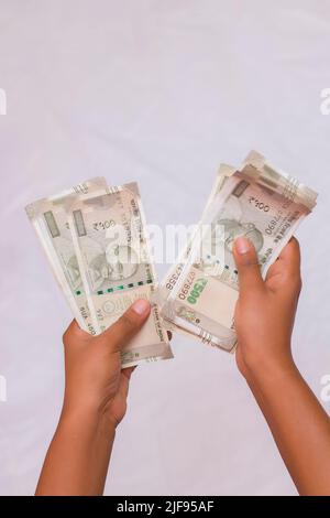 Hand holding Indian New 100 rupee notes on isolated background Stock ...