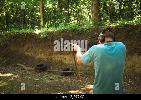 A Ukrainian civilian man is training to shoot an Akm machine gun during ...