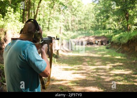 A Ukrainian civilian man is training to shoot an Akm machine gun during ...