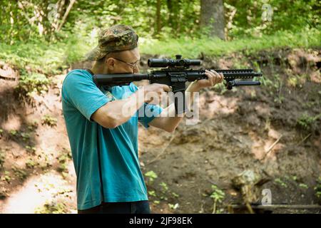 A Ukrainian civilian man is training to shoot an Akm machine gun during ...