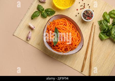 Composition with bowl of korean carrot salad and ingredients on light ...