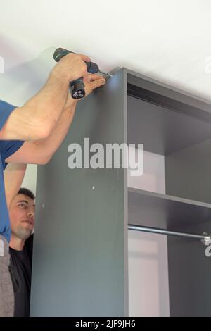 The process of screwing the screw, installing a sliding door wardrobe ...