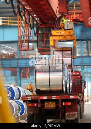 RIZHAO, CHINA - JUNE 30, 2022 - Workers hoist steel coils at a workshop ...