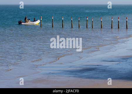 Red and white painted wooden bollard markers in the lagoon Stock Photo ...