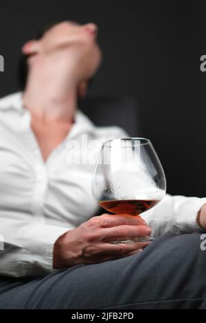 Drinking glass filled with alcohol held by woman in business clothes ...