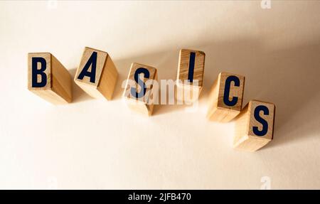 The word Basics on wooden cube push button on blue and white background ...