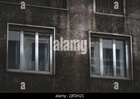 A gray apartment building with white windows Stock Photo - Alamy