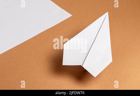 White paper plane on beige background Stock Photo - Alamy
