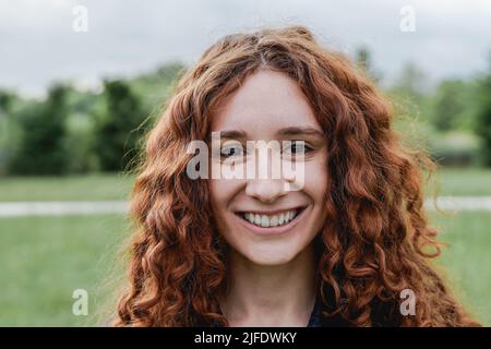 Headshot Portrait of happy ginger girl with freckles smiling looking at ...