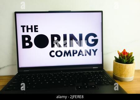 The Boring Company logo displayed on a phone screen and Elon Musk's ...
