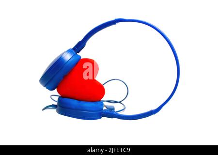 Wired headphones over a large red heart shape isolated on a neutral ...