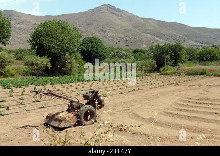 Rotovator sits idle in a cultivated field, Eristos valley, Tilos island ...