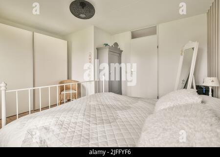 A spacious bright bedroom with a minimalistic bedside table and a large ...