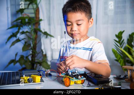 Asian kid boy plugging energy and signal cable to sensor chip with ...