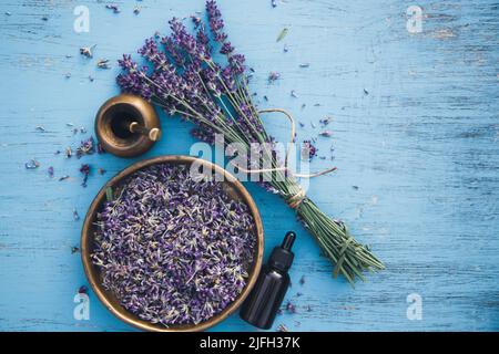 Flat lay of oil, bowl and bouquet of fresh lavender flowers on ...