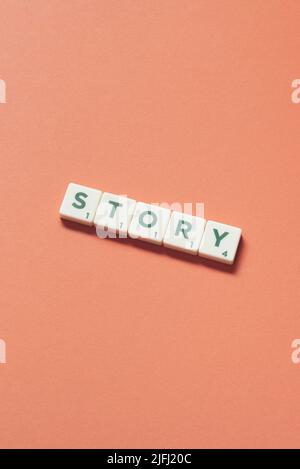 Story formed of scrabble tiles on white background Stock Photo - Alamy
