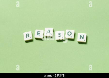 Reason formed of scrabble tiles on white background Stock Photo - Alamy