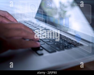 Hands man useing laptop computer with E-commerce technology icons on ...