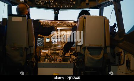 Plane captain and woman copilot fixing altitude on dashboard, using ...