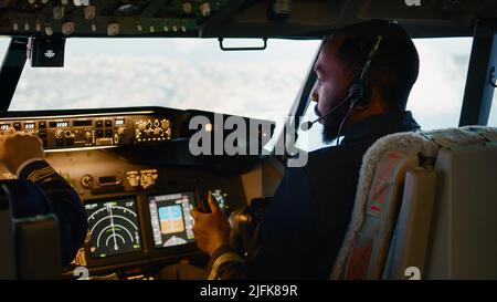 Team of captain and copilot throttling engine to fly airplane, using ...