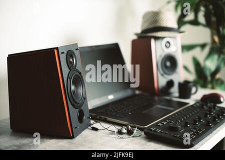 Modern speakers and laptop on wooden table near white brick wall Stock ...
