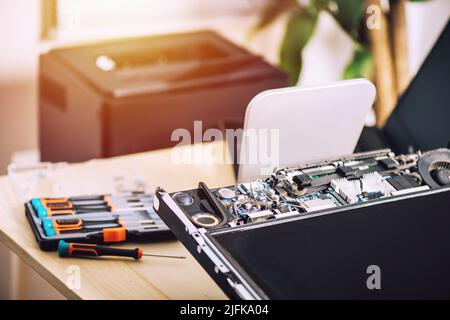 Desktop with broken disassembled laptop. Electronic parts of pc ...