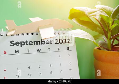 September 2022 green Desk calendar with pink alarm clock on wooden ...