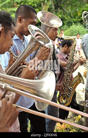 Villagers playing brass instruments during a rural orchestra ...